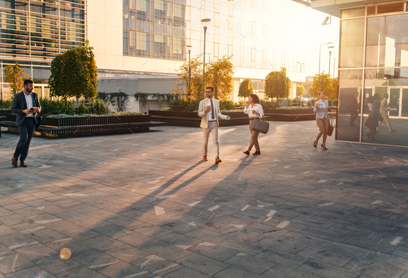 Group of business people walking outside in front of office buildings ...