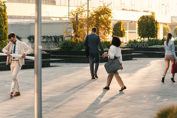 Group of business people walking outside in front of office buildings ...