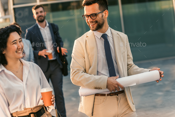 Group of business people walking outside in front of office buildings ...