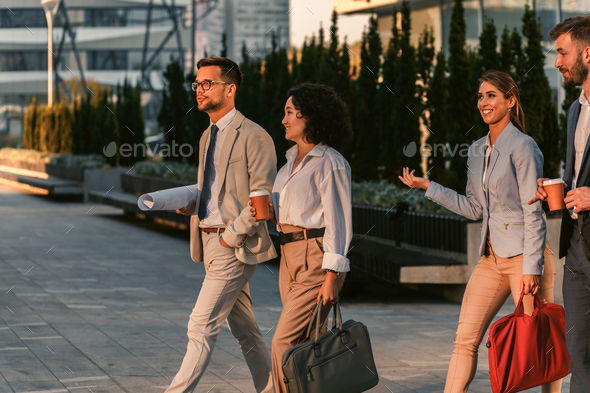 Group of business people walking outside in front of office buildings ...