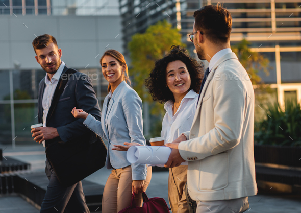 Group of business people walking outside in front of office buildings ...