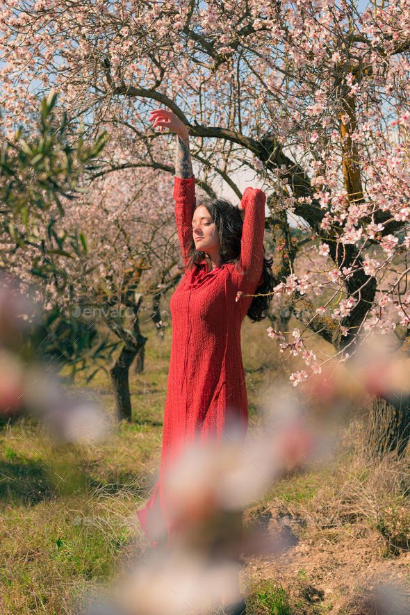 Portrait of a woman posing with an almond tree and a spring environment Stock Photo by ...