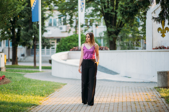 Gorgeous Caucasian female in stylish purple and black outfit walking in ...