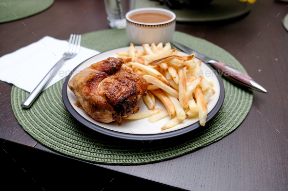 roast chicken dinner with fries and sauce Stock Photo by wirestock