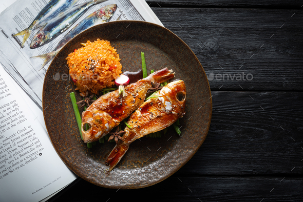Top view of fried fish with rice on a plate Stock Photo by wirestock
