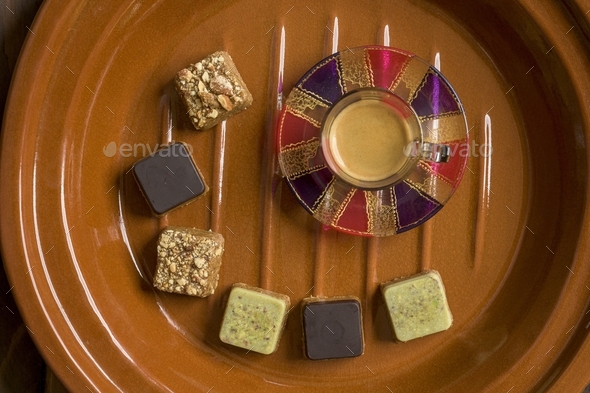Overhead shot of different types of square-shaped sweets with tea on a ...