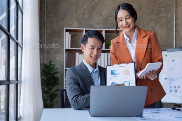 Focused Asian business people teampresenting charts and graphs and ...