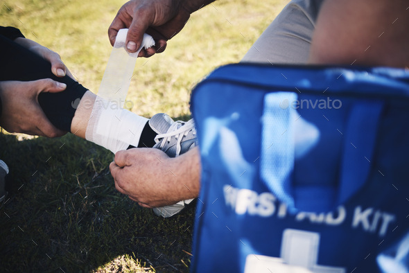 First aid, hands and man medic with ankle sports injury at field for ...