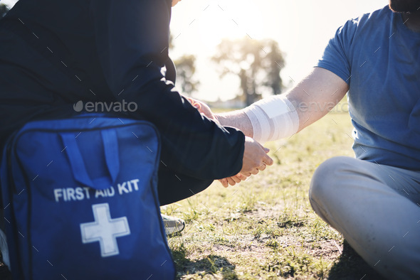 First aid, help and arm injury by man with medic on the ground during ...