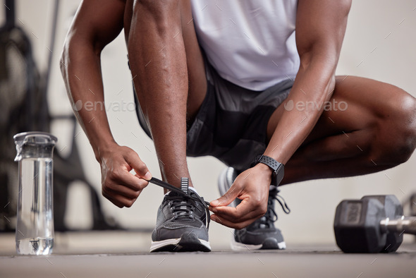 Hands, fitness and tie shoes in gym to start workout, training or exercise practice. Sports ...