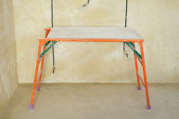 Iron construction table on the background of the wall. Apartment ...