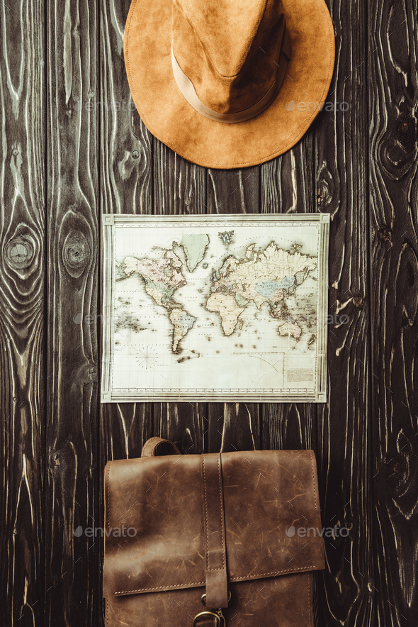 top view of arranged hat, map and bag on dark wooden surface Stock ...