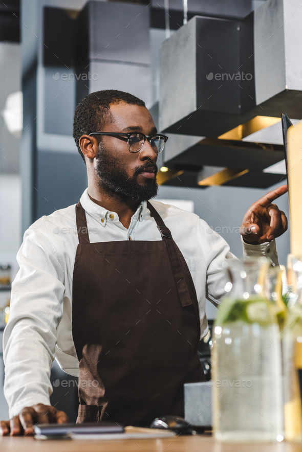 handsome young african american barista in eyeglasses working in coffee ...