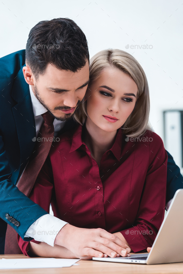 Handsome Businessman Flirting With Beautiful Female Colleague Using