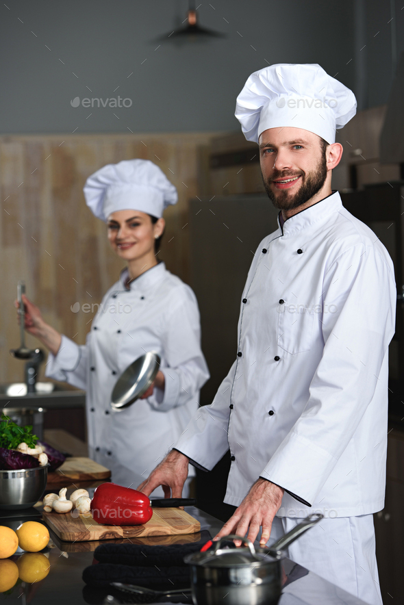 Professional chefs man and woman cooking in restaurant kitchen Stock ...