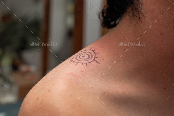 Shoulder tattoo of a man made with handpoke technique. Stock Photo by ...