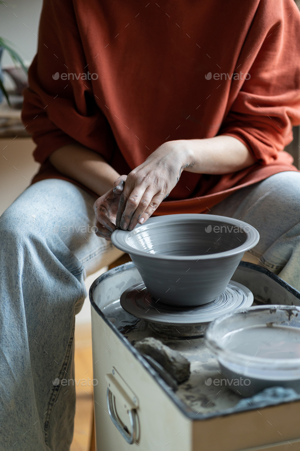 Ceramic master creating handmade stoneware on wheel in studio, forming ...