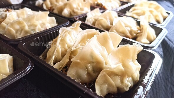 Many Japanese street food snack gyoza on dark plastic tray for little ...