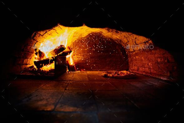 Pizza baking by the fire in an oven - Neapolitan oven pizza Stock Photo ...