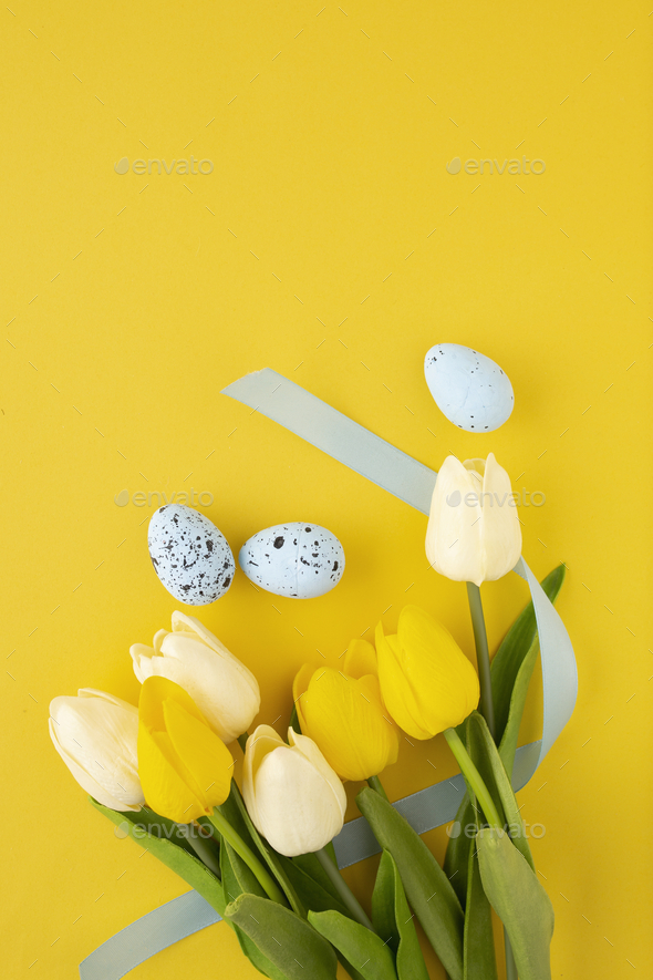 Yellow Easter background with beautiful tulip flowers and speckled eggs ...