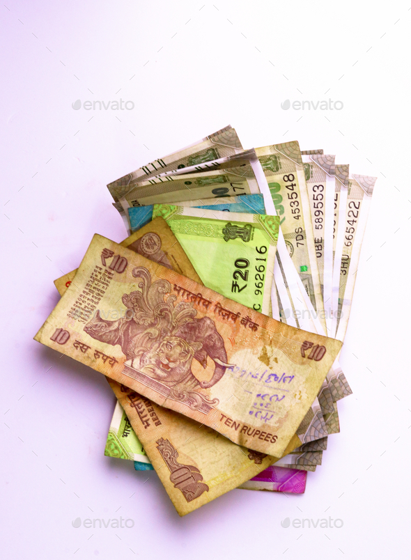 Vertical shot of Indian rupee banknotes isolated on a light purple ...