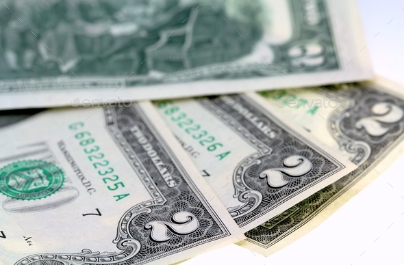 Closeup shot of two-dollar money laid in a white surface with a blurred ...