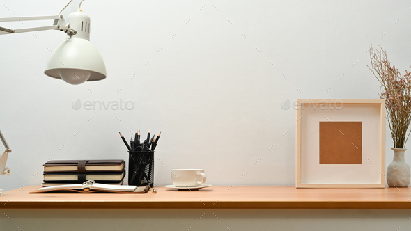 Interior of home office with books, pencil holder and picture frame on ...