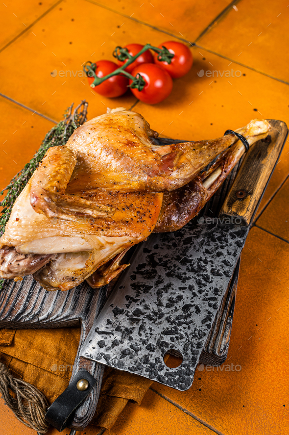 Grilled guinea fowl with herbs and spices on butcher board, cooked game ...