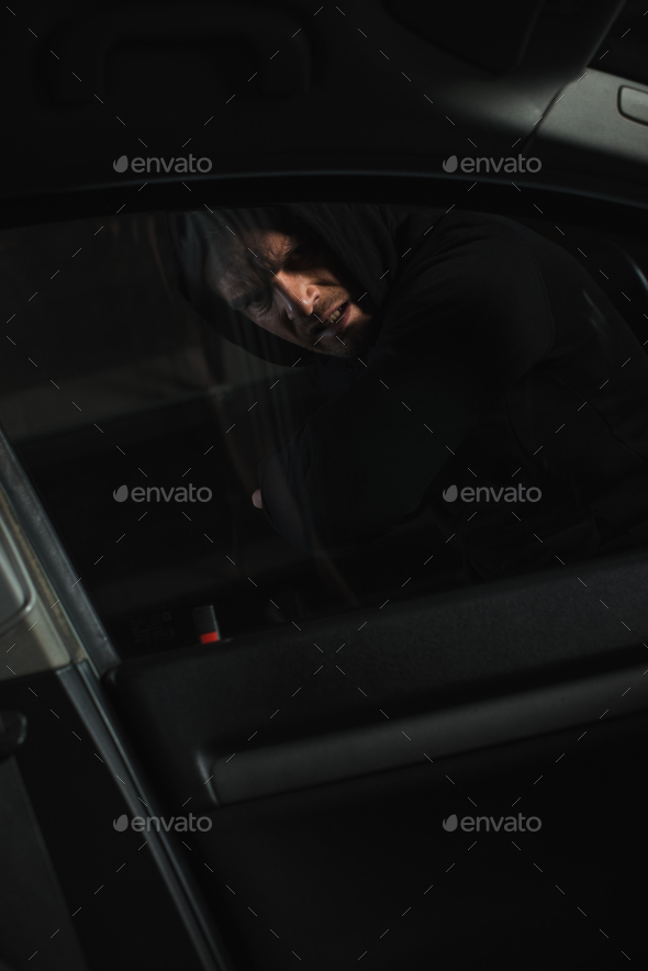 concentrated male robber breaking car window by elbow Stock Photo by ...