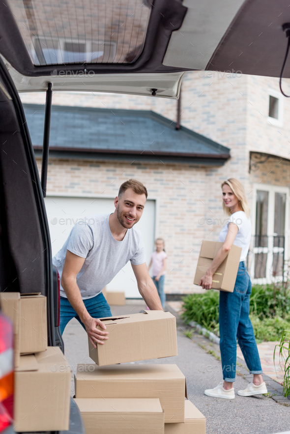 couple with cardboard boxes for relocation into new house and their ...