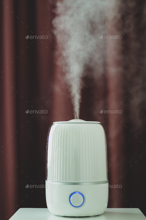 White ultrasonic humidifier on a dark background. Water vapor. Stock ...