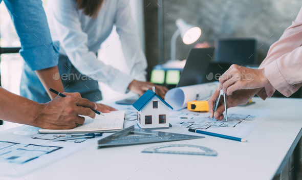 A group of architects are designing a house model Stock Photo by paegagz