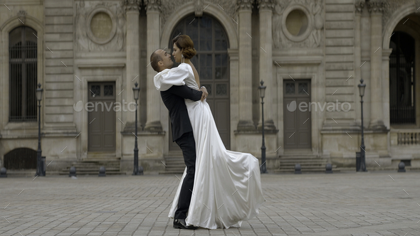 Happy just married groom carry on his hands the bridge in Paris, France ...