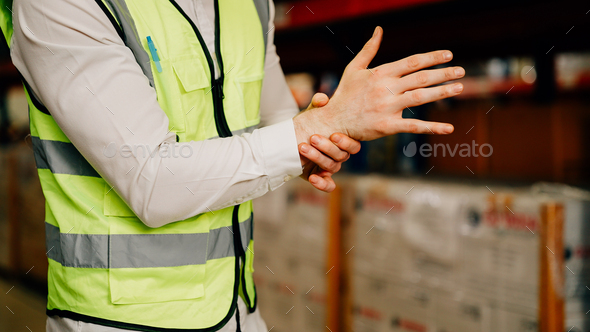 Hardworking male warehouse engineer suffering from hand injury Stock ...