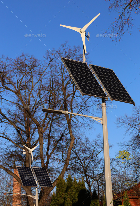 Solar panel with small wind turbine over it. Stock Photo by wirestock