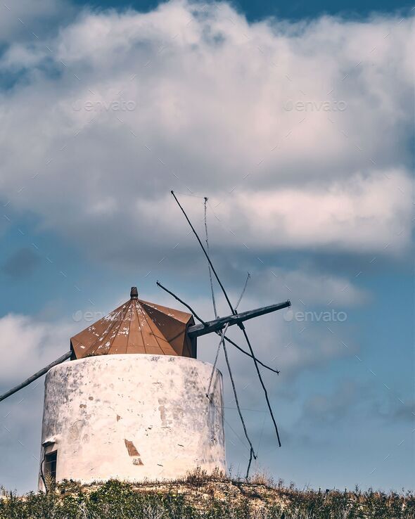 Old abandoned mill on a hill in the countryside under blue sky with ...
