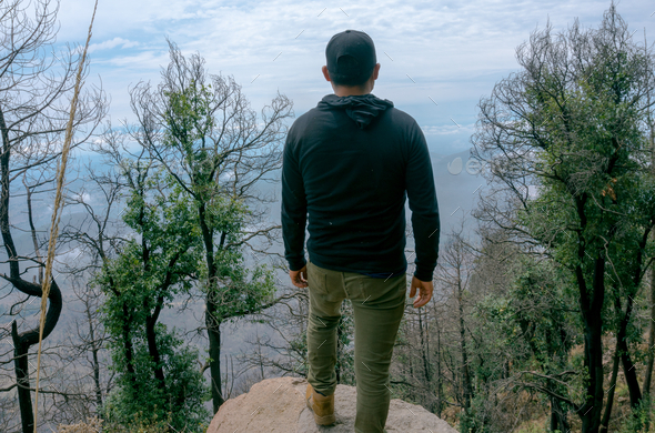 Male standing on the rock during a hiking trail to El Pinal volcanic ...