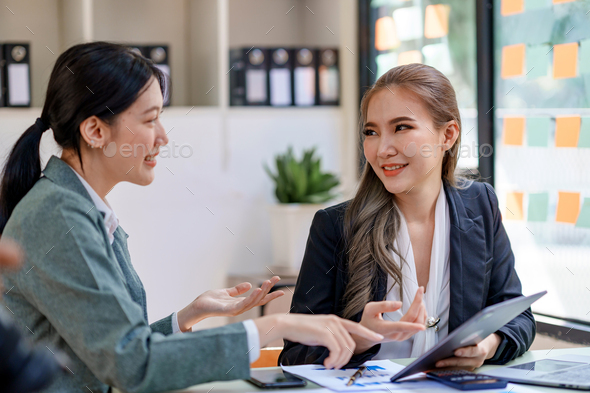 Two Young Asian businesswoman discuss with new startup project Idea ...