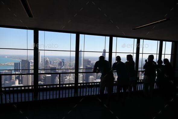 Group of people inside a building looking at the city Stock Photo by ...