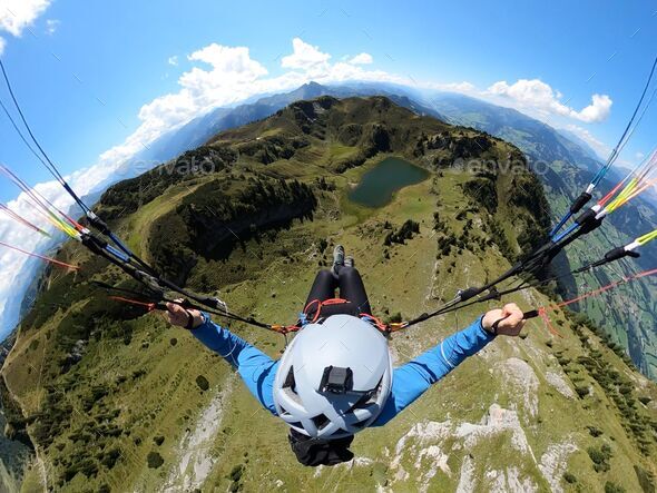 Top view of a skydiver paragliding on a scenic landscape with a ...