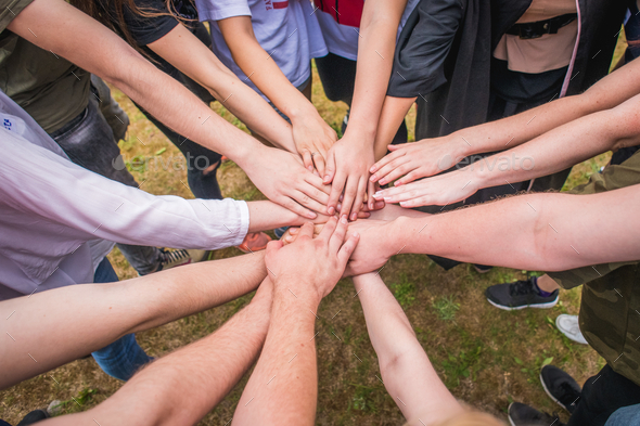 High angle shot of unrecognizable adults and teens showing unity with ...