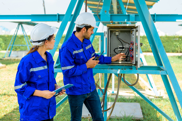 Workers installing solar panels, Engineer team at solar panel farm ...