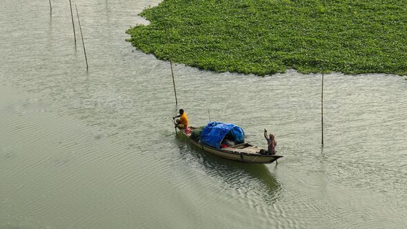 Bird's eye view of a fisherman rowing a small wooden boat on the ...