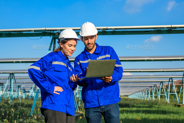 Workers installing solar panels, Engineer team at solar panel farm ...