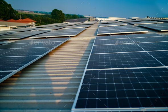 Solar panel installer installing solar panels on roof of warehouse ...