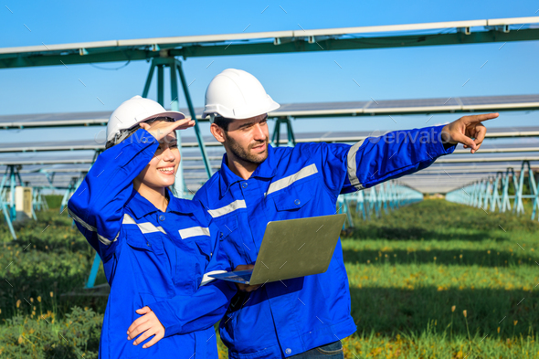 Workers installing solar panels, Engineer team at solar panel farm ...