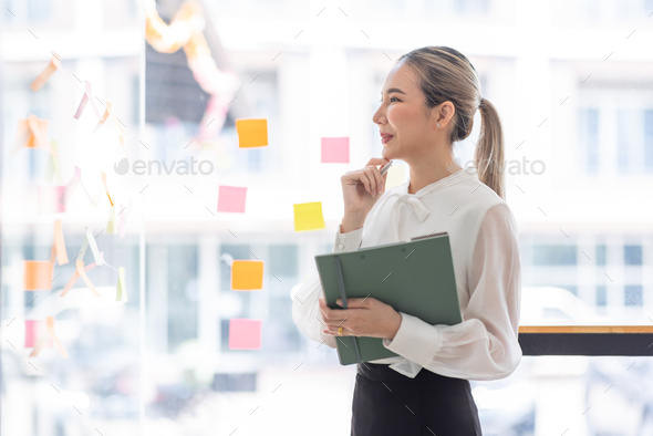 Young Asian woman Creative team use post it notes to share idea sticky ...
