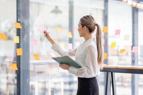 Young Asian woman Creative team use post it notes to share idea sticky ...