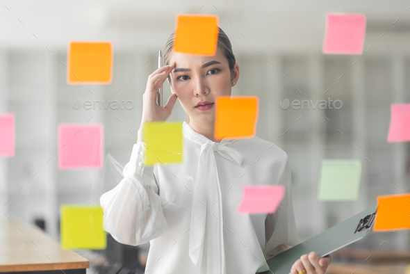 Young Asian woman Creative team use post it notes to share idea sticky ...