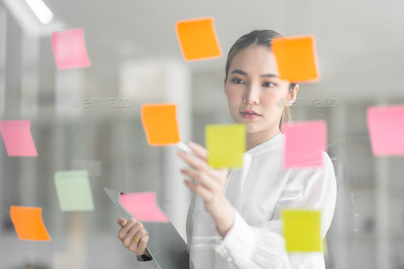 Young Asian woman Creative team use post it notes to share idea sticky ...